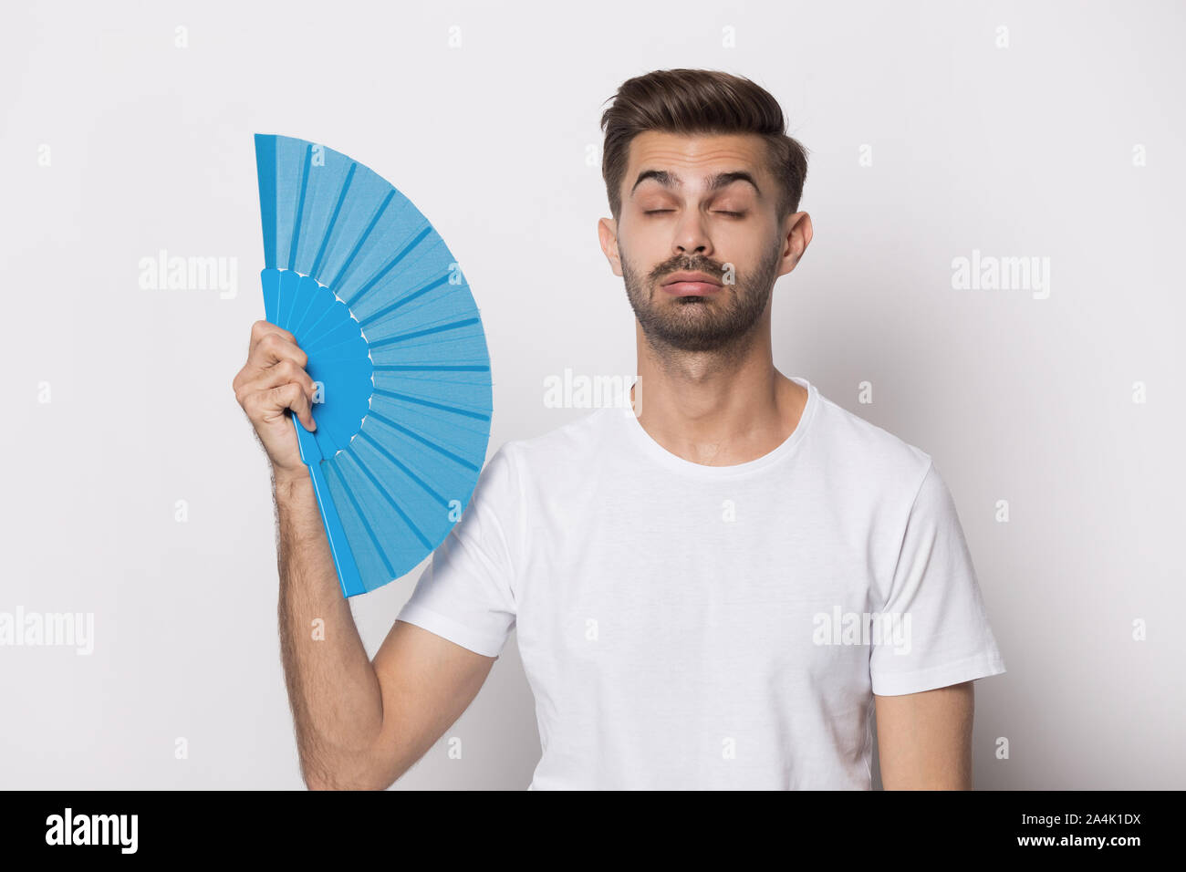 Unhappy man feel overheated use hand waver Stock Photo - Alamy