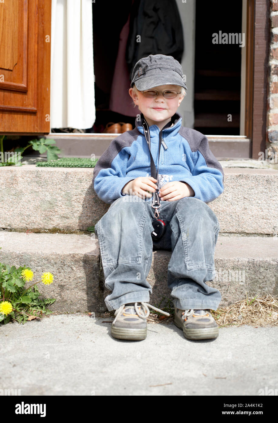 Boy sitting on steps Stock Photo - Alamy