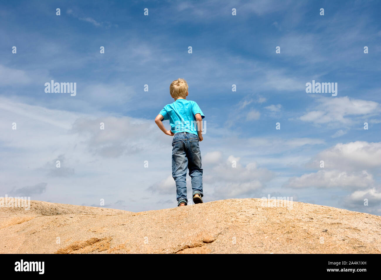 Boy on rock Stock Photo - Alamy