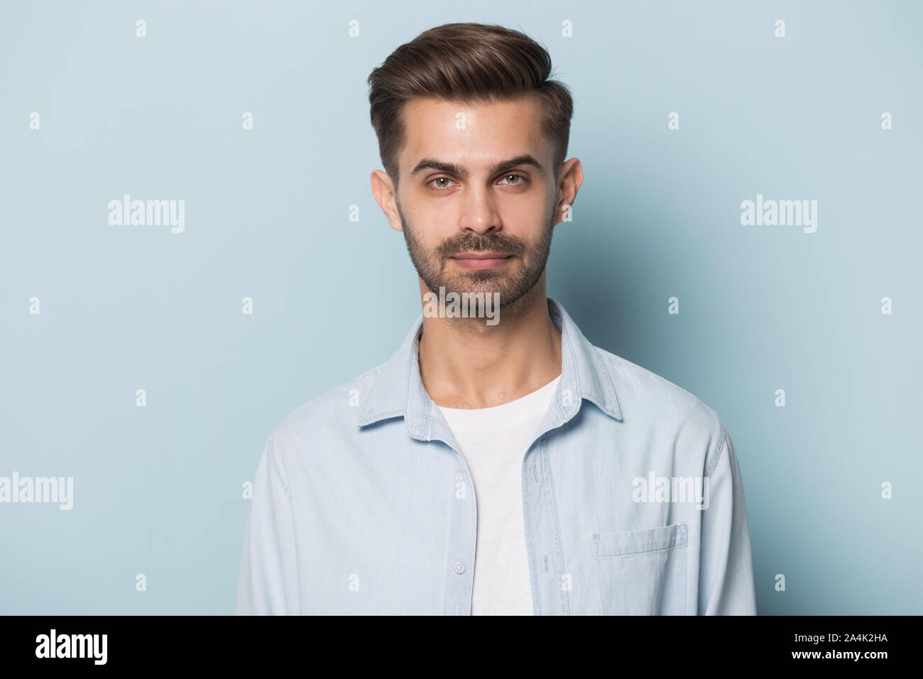 Headshot of serious caucasian young man posing on blue background Stock ...