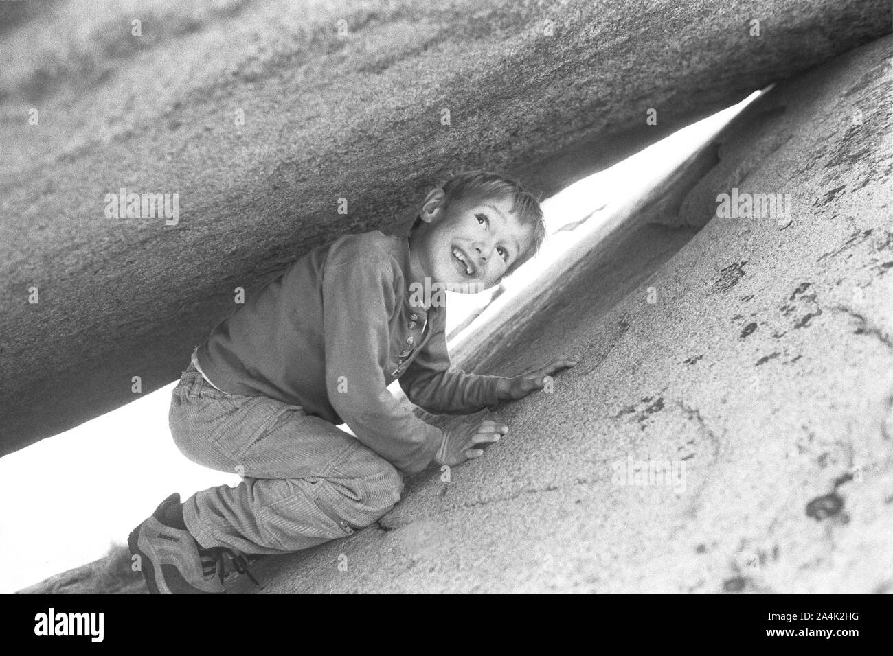 Boy hiding under rock Stock Photo - Alamy