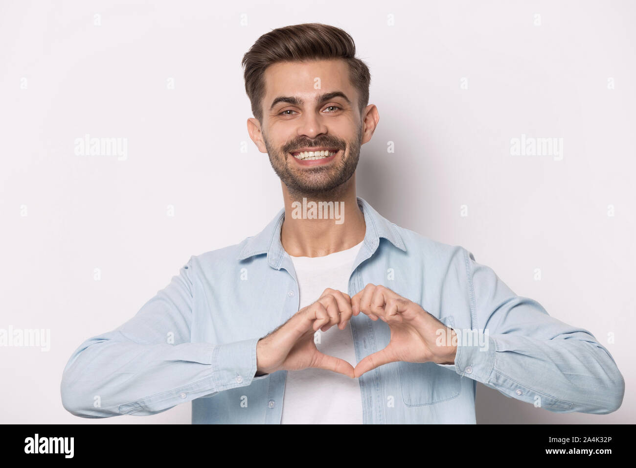 Smiling man look at camera showing heart with hands Stock Photo - Alamy