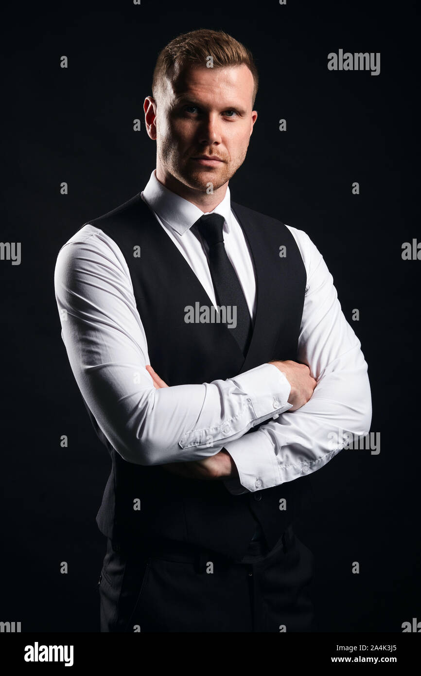 Confident young strong muscular bodyguard standing with crossed arms ...