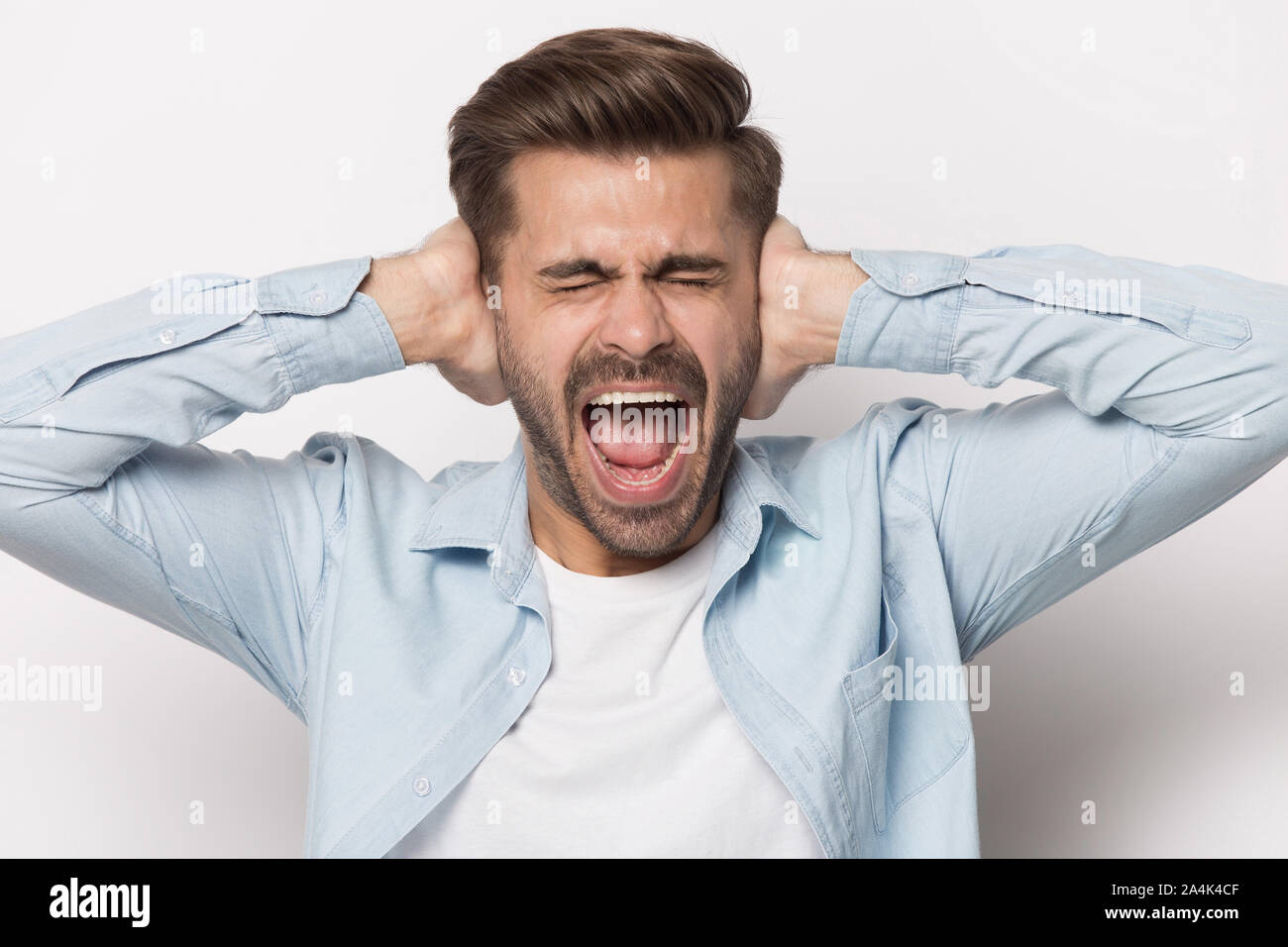 Furious man close ears scream avoiding loud noise Stock Photo - Alamy