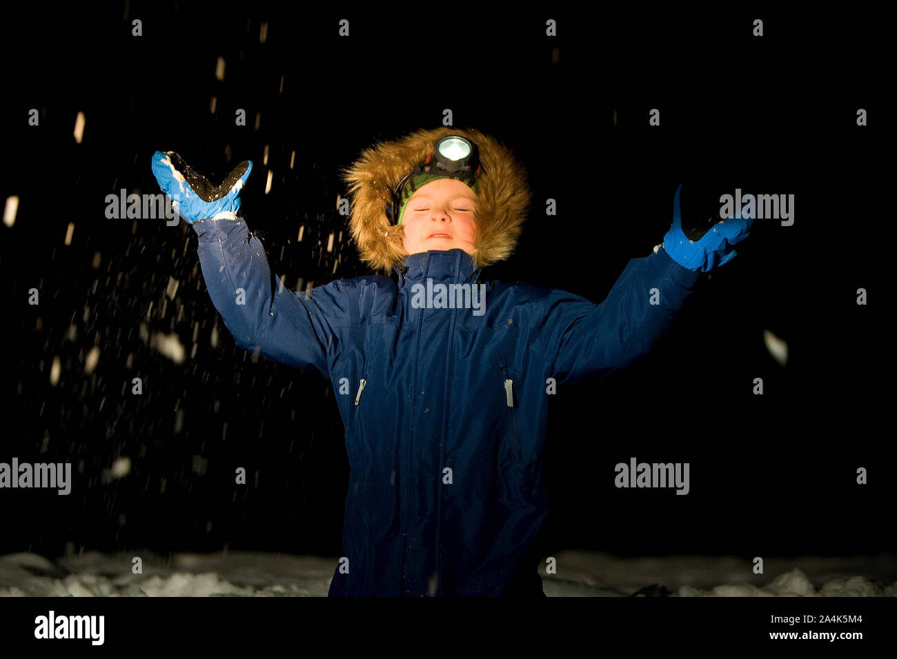 portrait of child wearing flashlight playing in snow Stock Photo - Alamy