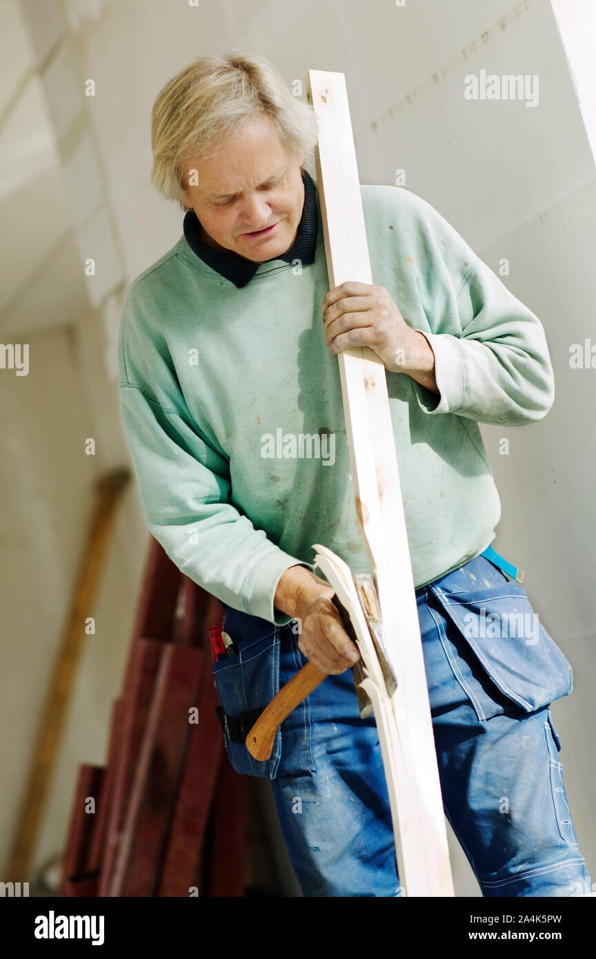 Builder working with hammer Stock Photo - Alamy