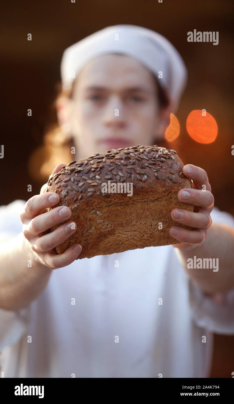 Model Young man holding a bread in his hands Stock Photo - Alamy