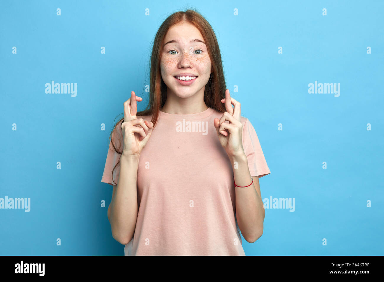 Superstitious ginger student swith freckles crossing fingers for good ...