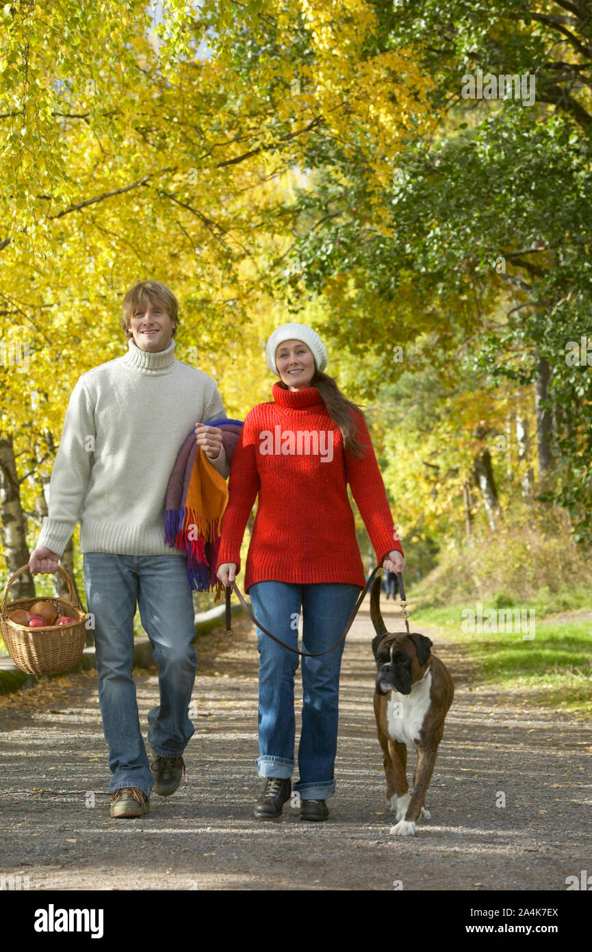 Couple walking the dog Stock Photo - Alamy