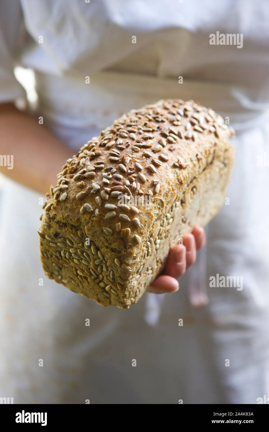 Baker holding loaf of bread Stock Photo - Alamy