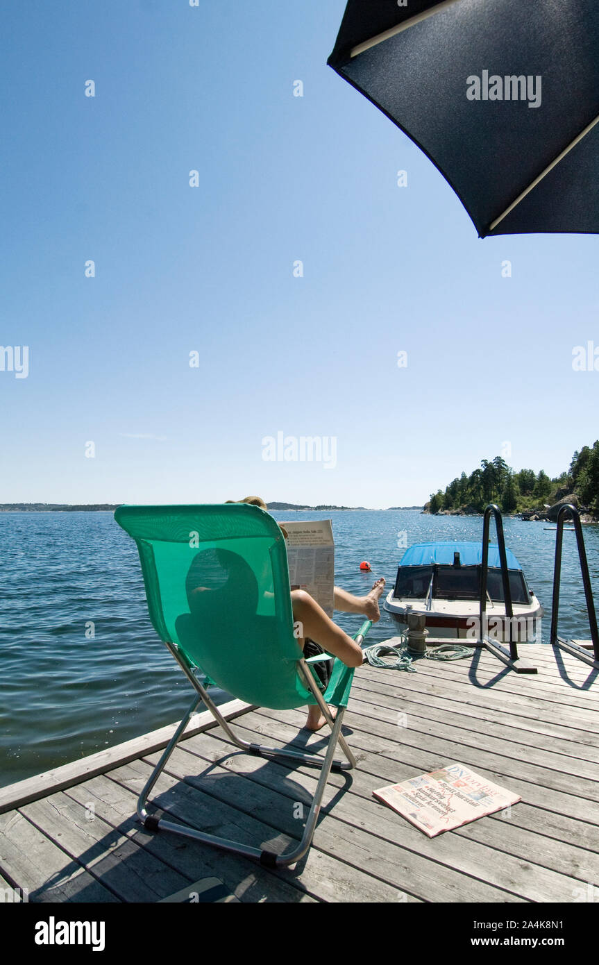 Reading newspaper by the sea Stock Photo - Alamy