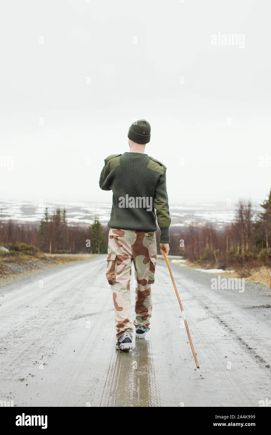 Military exercise in forest. Soldier using walking stick walking on ...