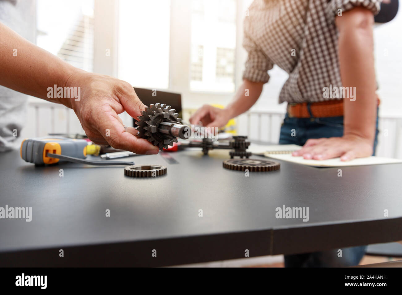 Engineer discussing and designing about mechanical gear parts in office ...