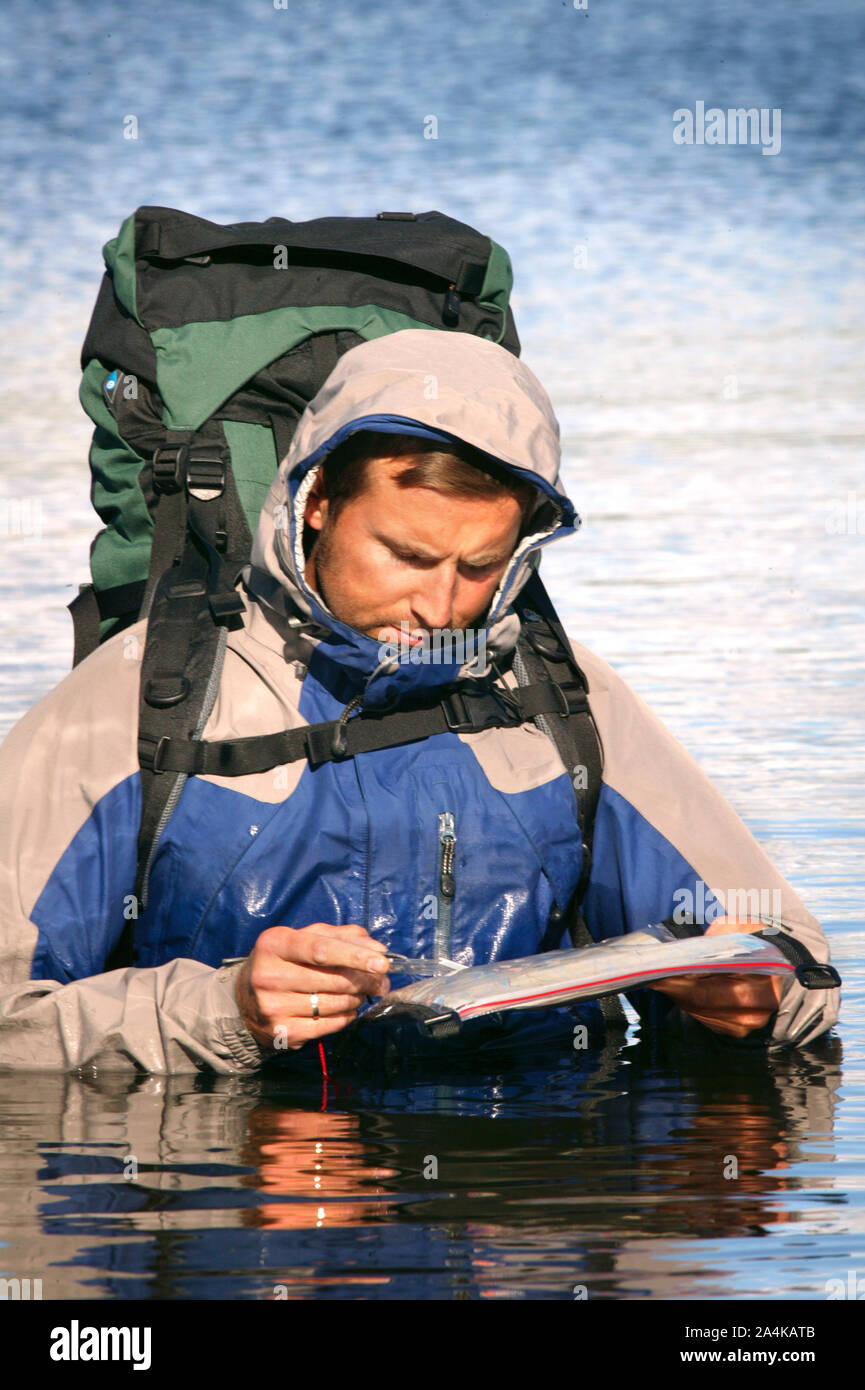 Man walking /hiking in water - reading map- strange fresh water ...