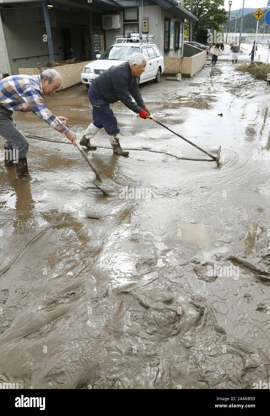 Residents clean up mud on a road in Marumori, Miyagi Prefecture ...