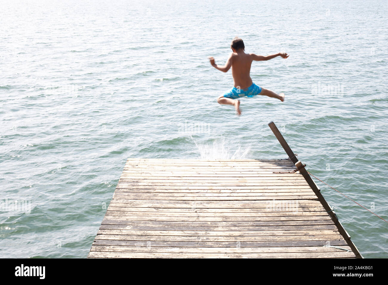 Boy jumping in sea Stock Photo - Alamy
