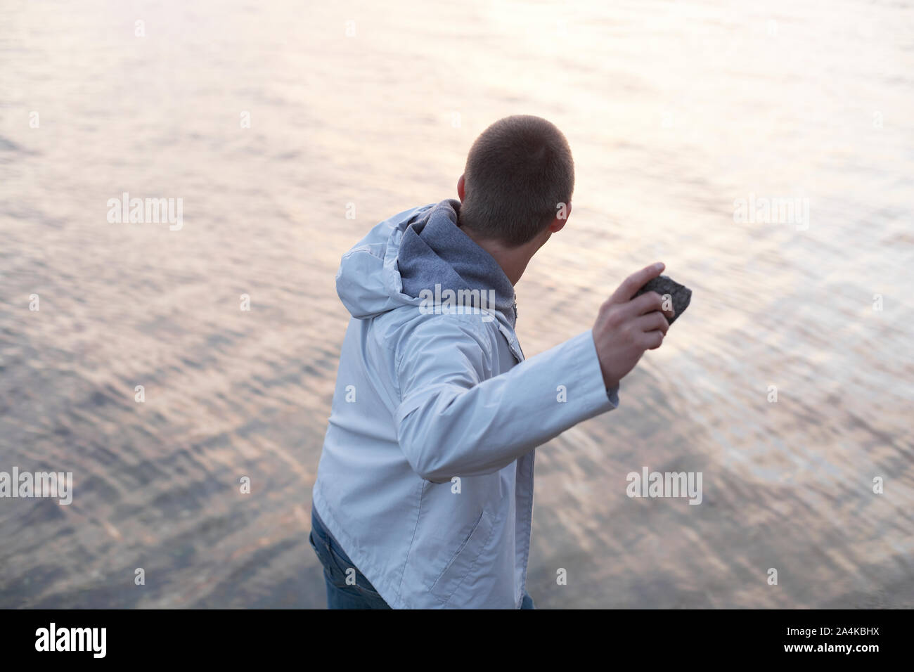 Throwing/skipping stone/rock in water Stock Photo - Alamy
