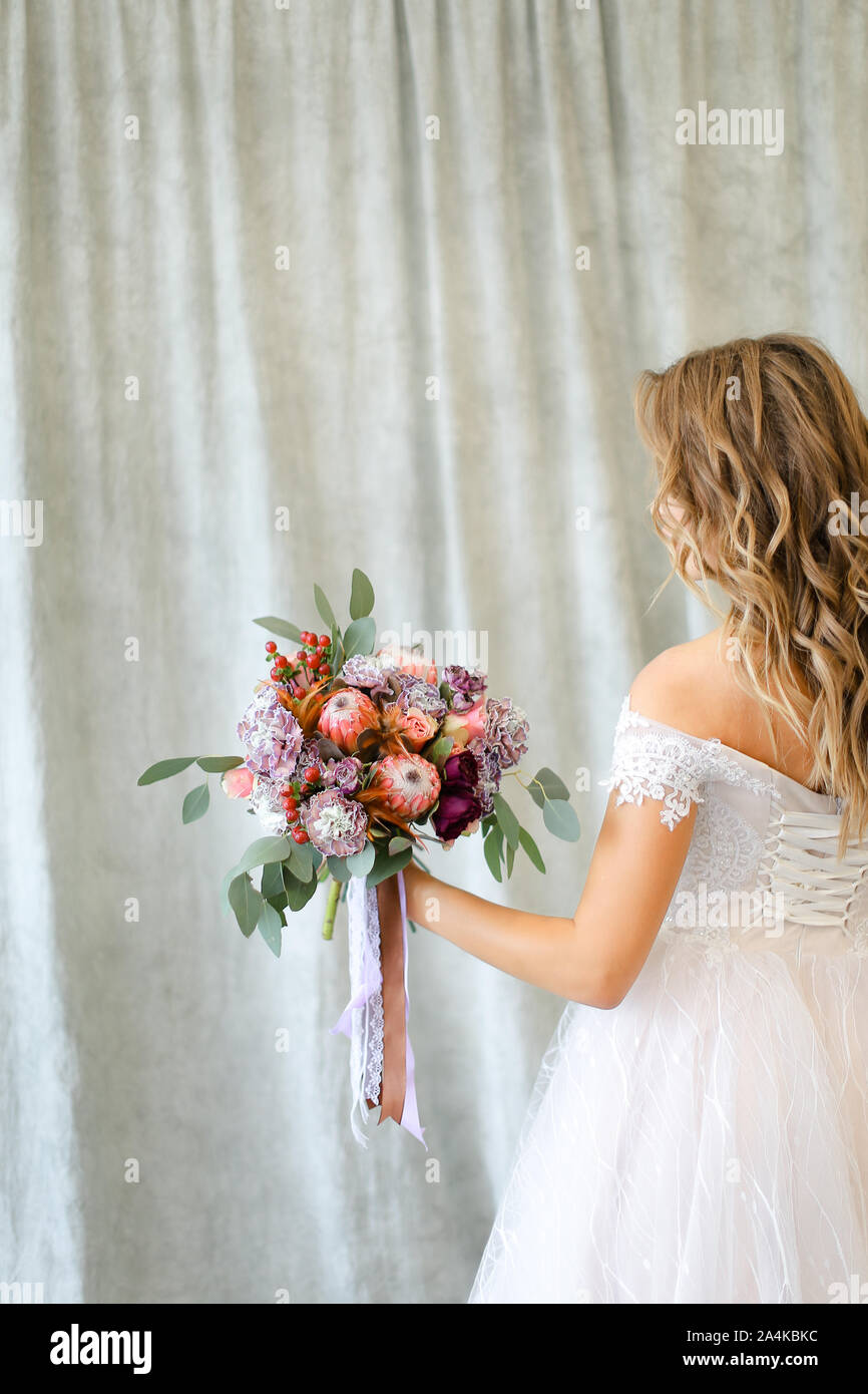 Back view of young caucasian bride standing at photo studio with ...
