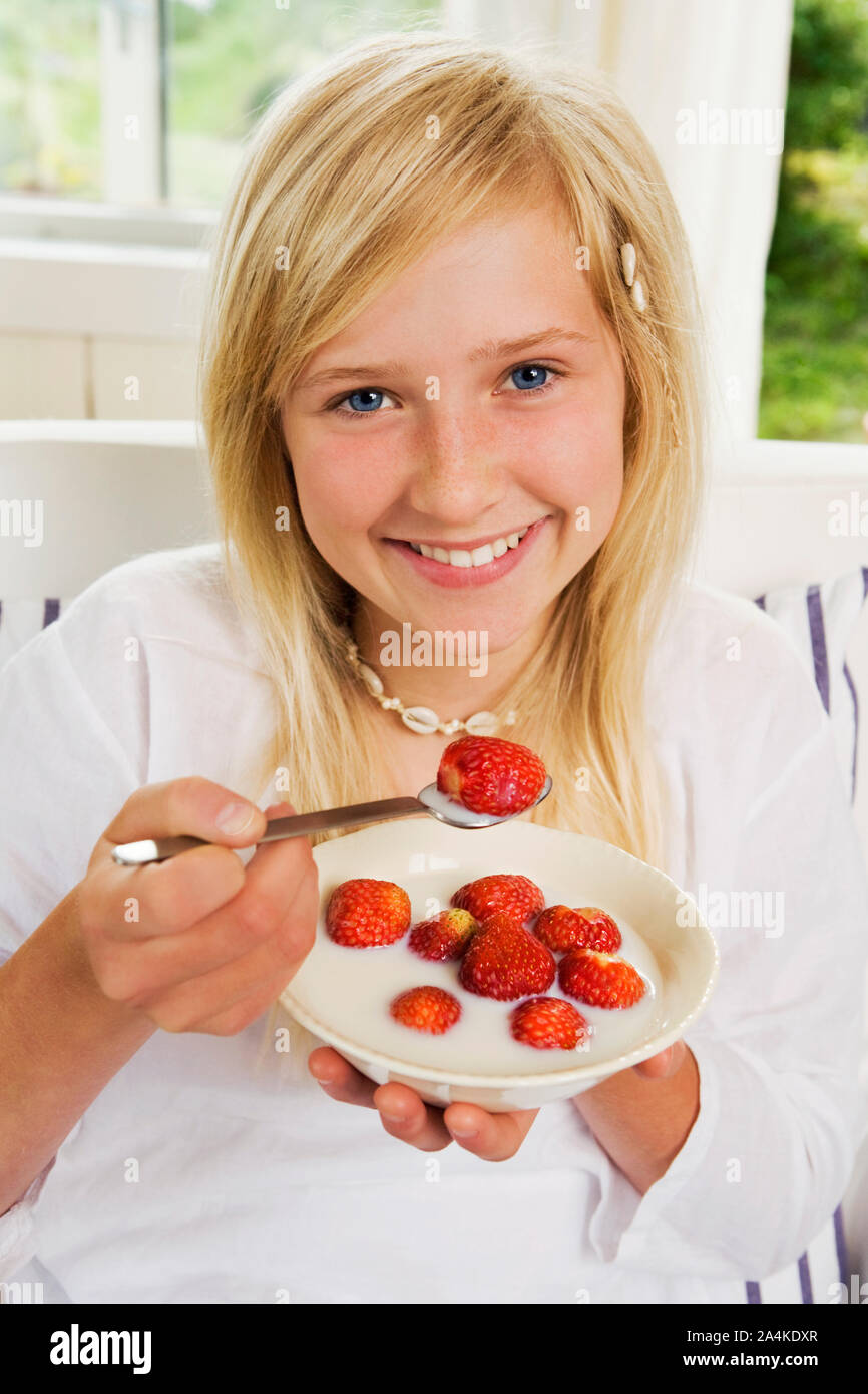 Girl eating strawberries Stock Photo - Alamy