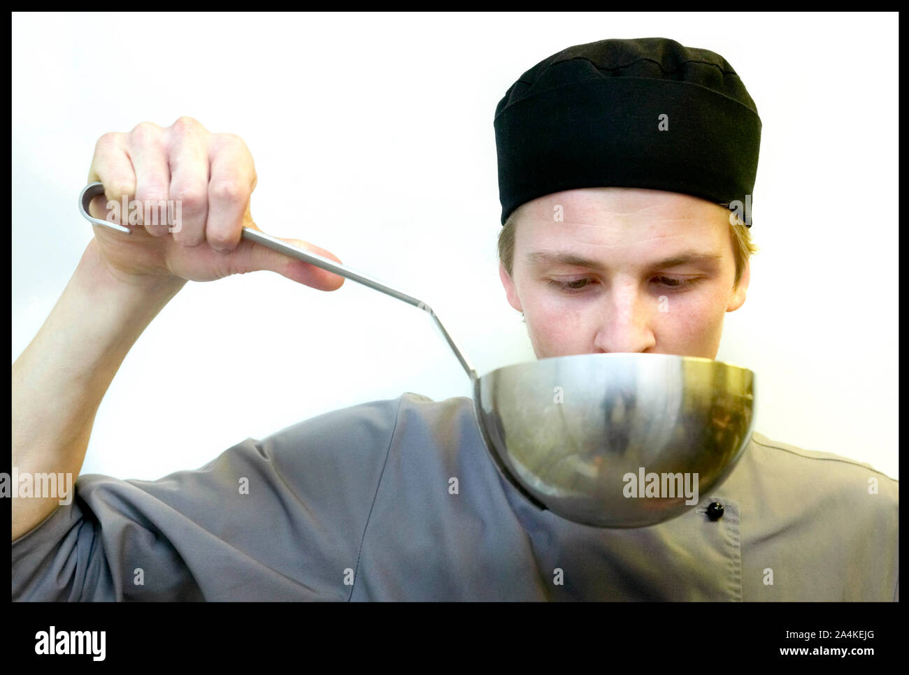 Male cook tasting the food Stock Photo - Alamy