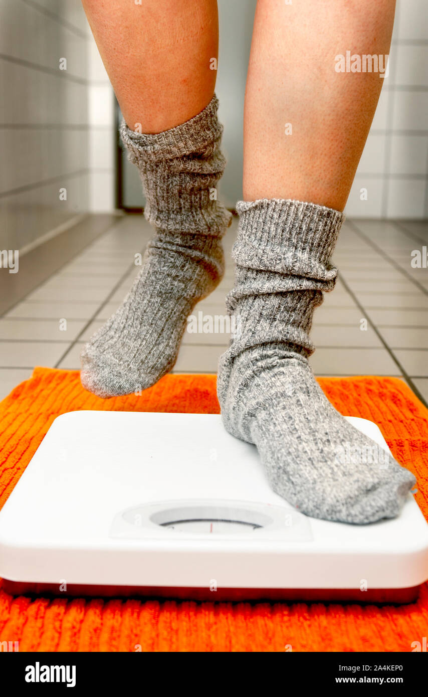 Standing on bathroom scales Stock Photo - Alamy