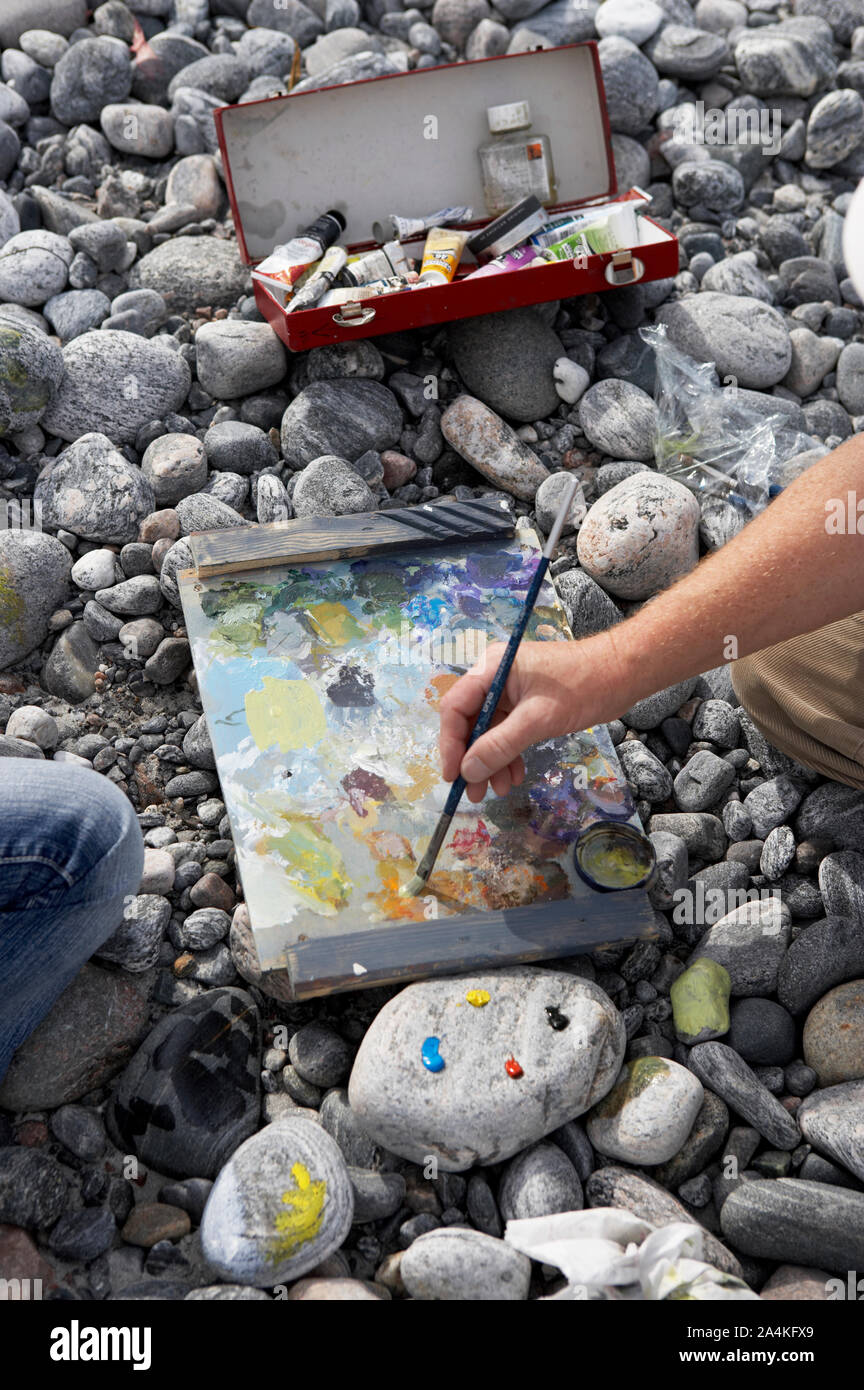 Artist painting picture on pebble beach Stock Photo - Alamy