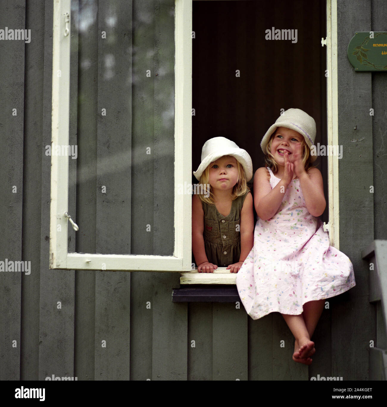 Two girls in a window Stock Photo - Alamy
