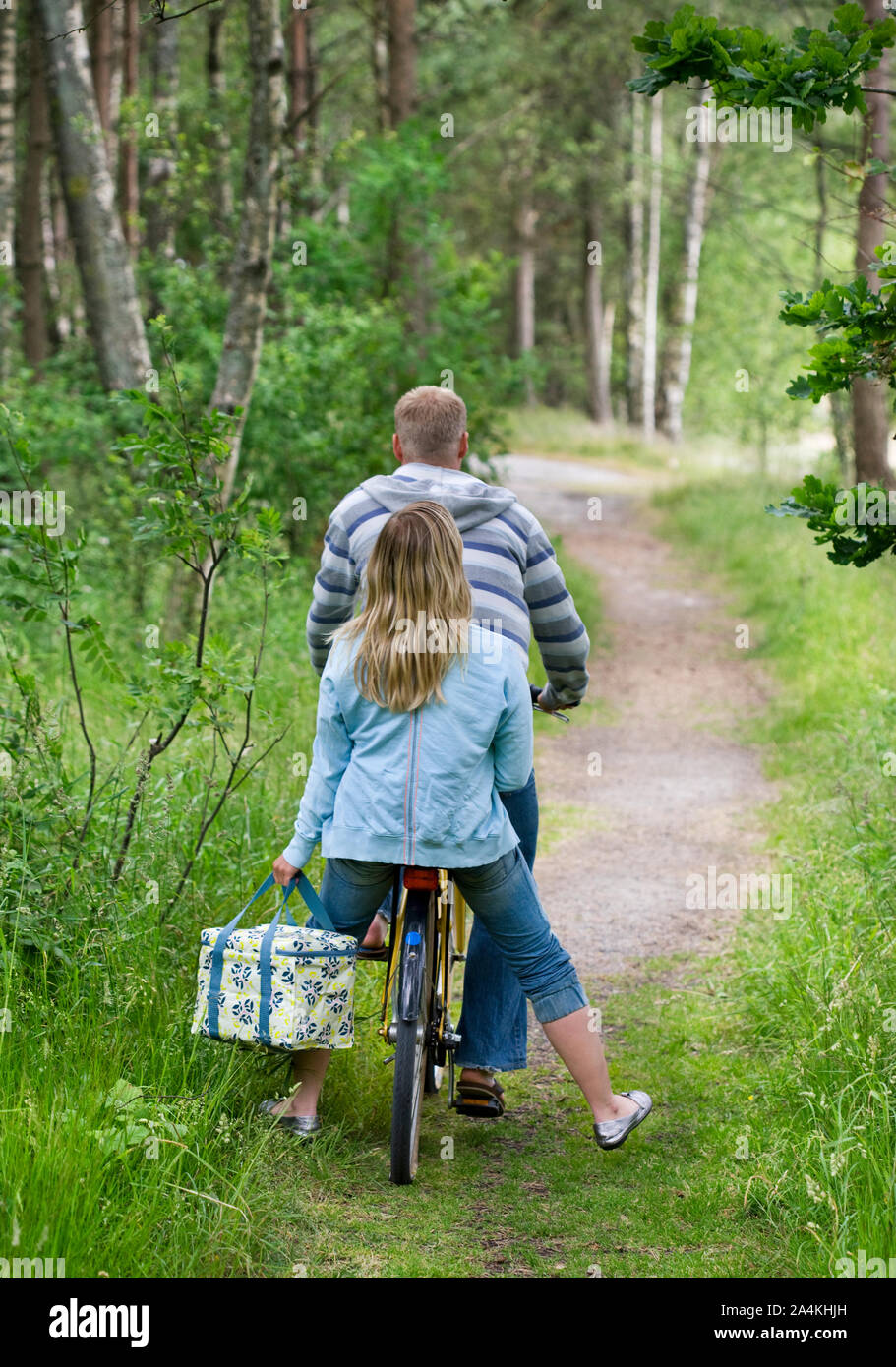 Couple on one bicycle Stock Photo - Alamy