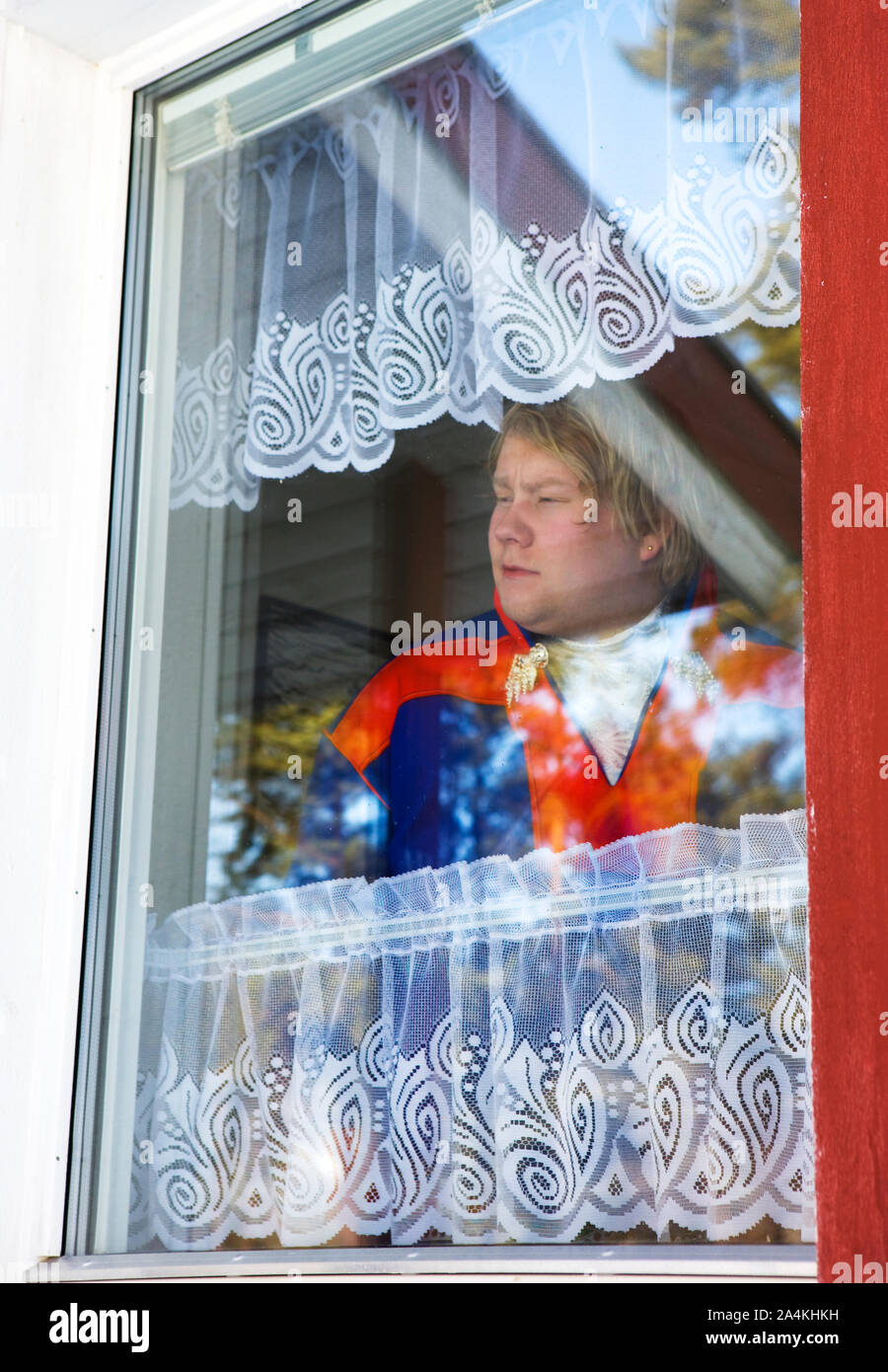 Young Laplander man looking out of kitchen window. Lapp / Lapps ...