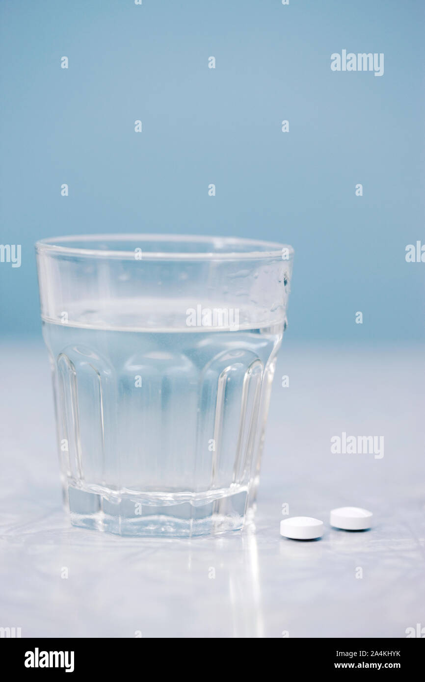 Tablets and glass of water Stock Photo - Alamy