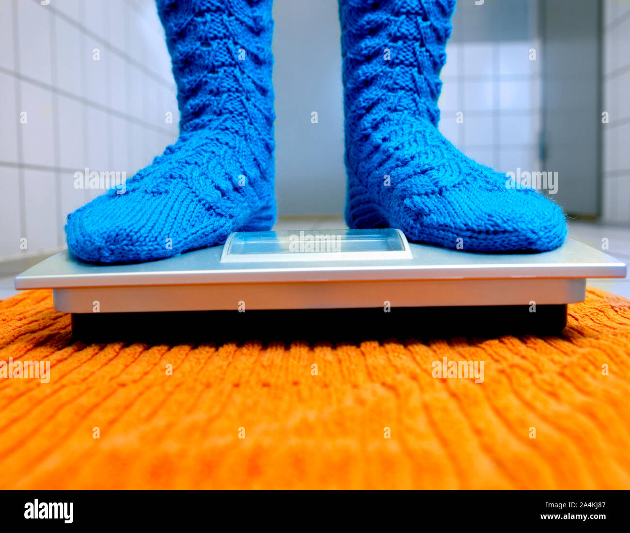 Woman standing on scales Stock Photo - Alamy