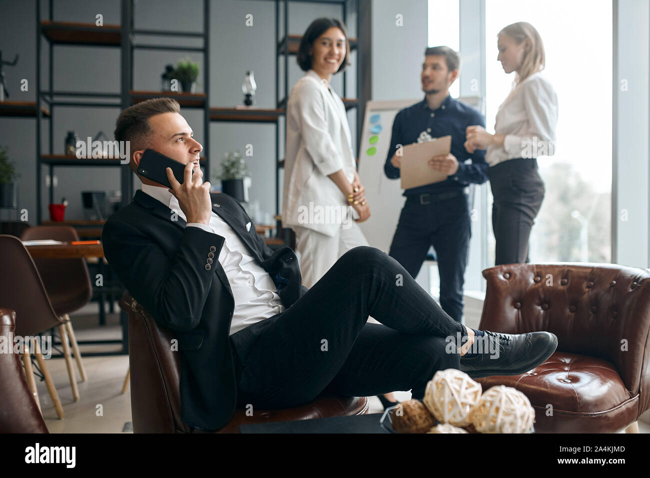 Young happy successful smart businesswoman sitting with crossed legs on ...