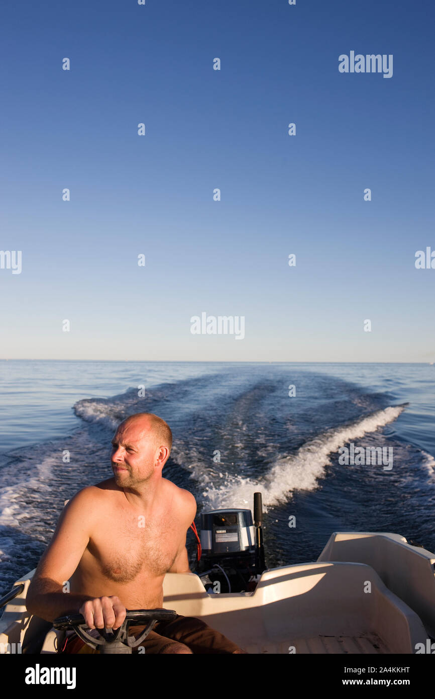 Man driving motor boat Stock Photo - Alamy