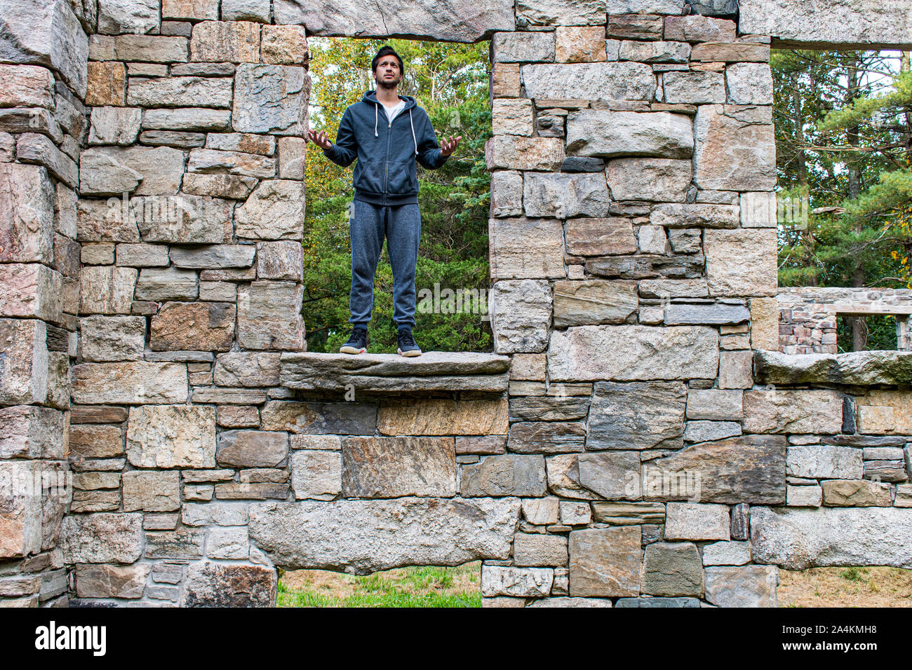 frustrated young man outside standing in window of abandoned building ...