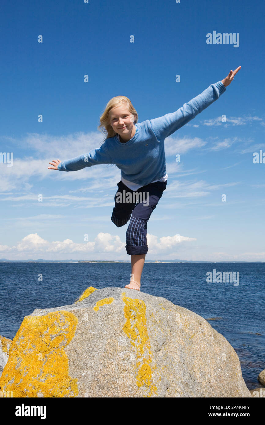 Girl balancing on rock Stock Photo - Alamy