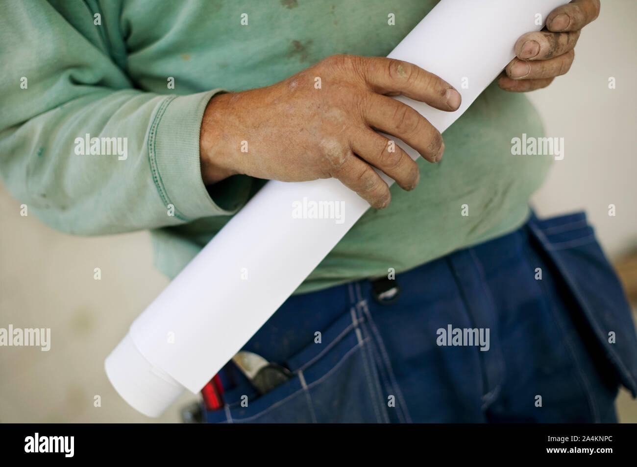 Workman holding construction plan Stock Photo - Alamy