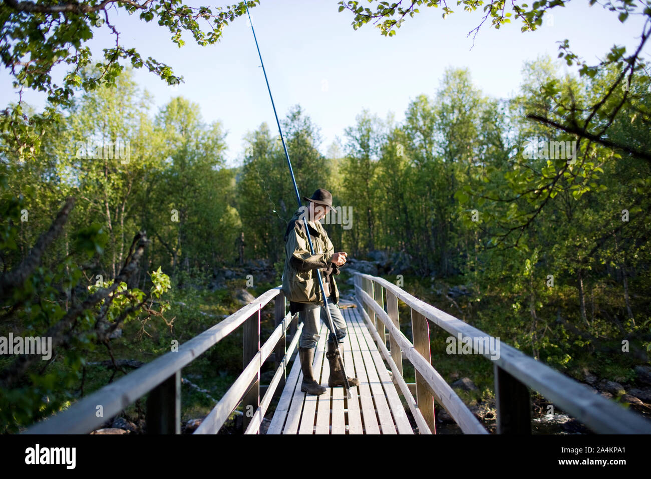 Man fishing from a bridge Stock Photo - Alamy