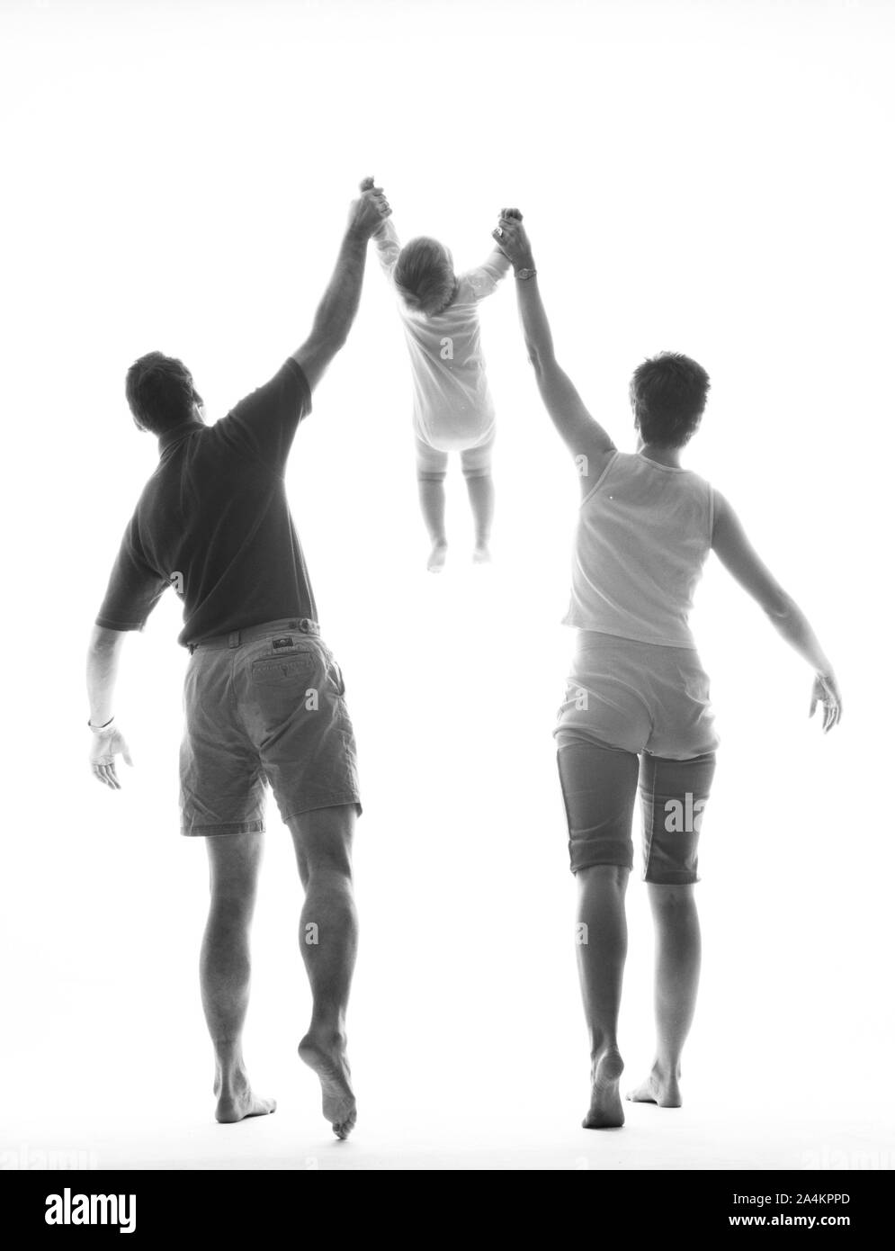Parents lifting child Stock Photo - Alamy