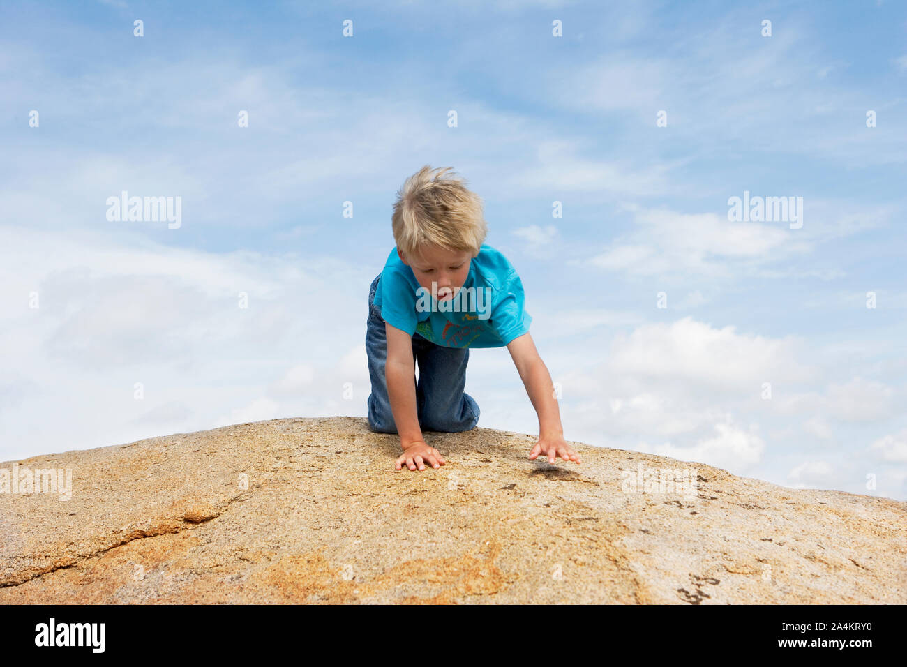 Boy playing on rock Stock Photo - Alamy
