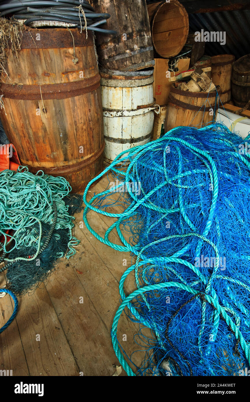 Fishing nets and barrels in a shed Stock Photo - Alamy