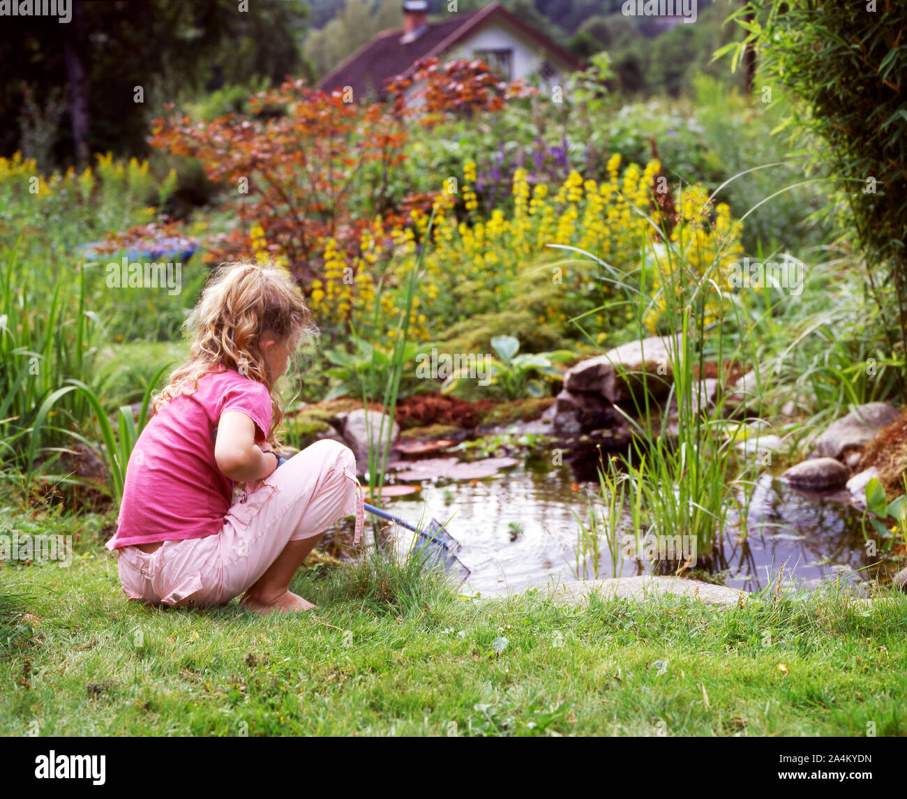 Girl at garden pond Stock Photo - Alamy