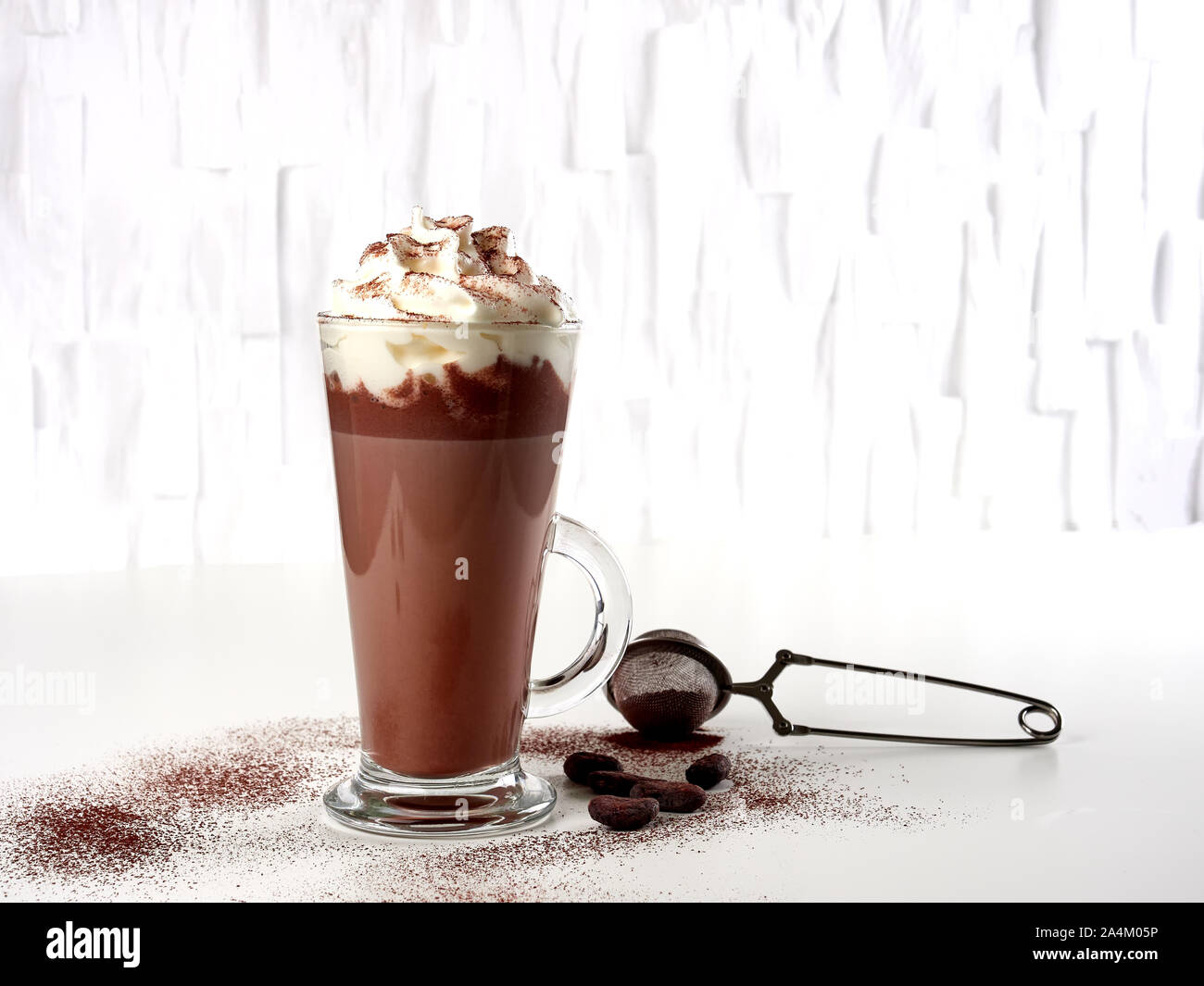 Hot chocolate latte with whipped cream, in tall glass, sprinked with ...