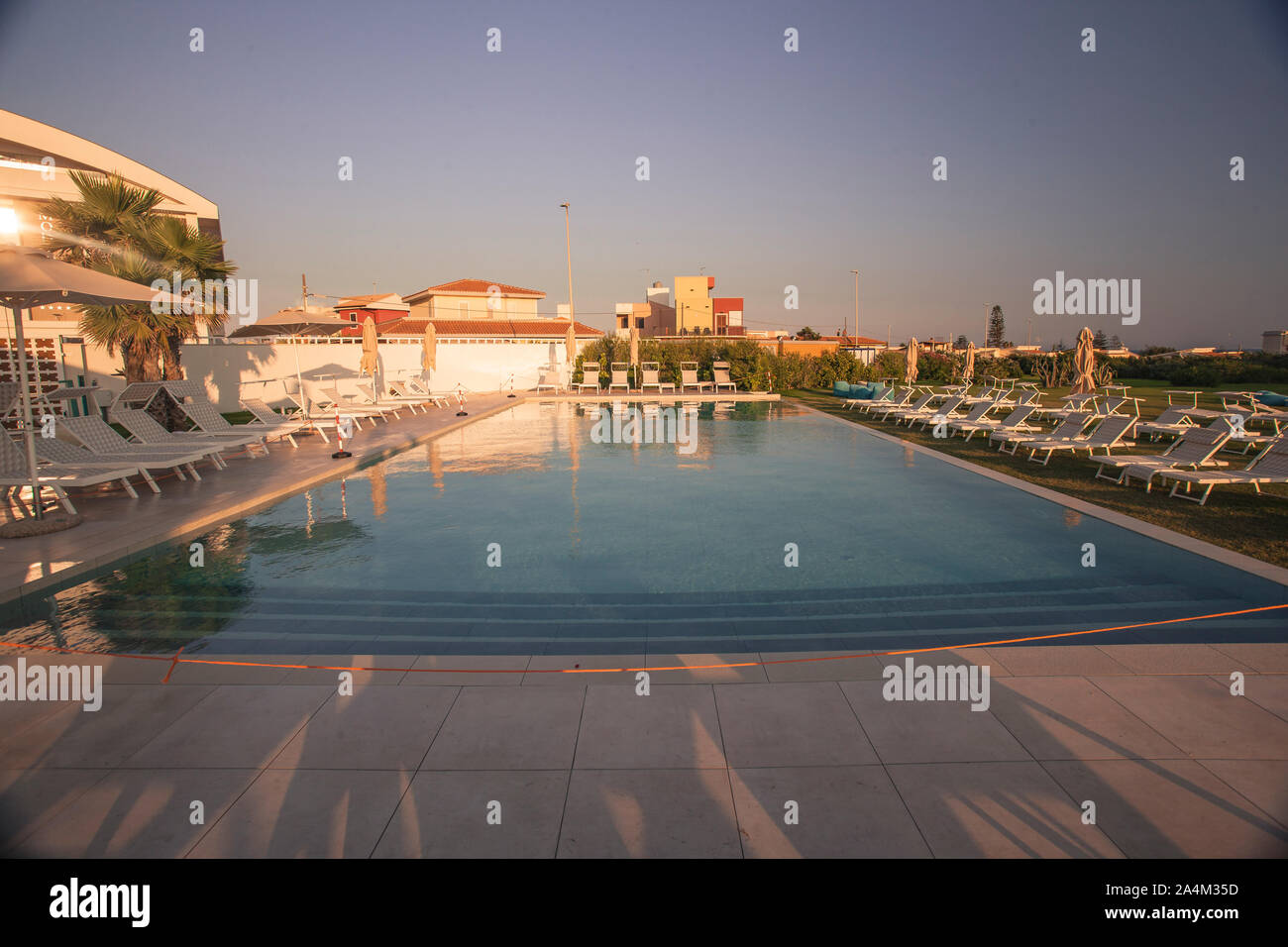 Resort pool at sunset Stock Photo - Alamy