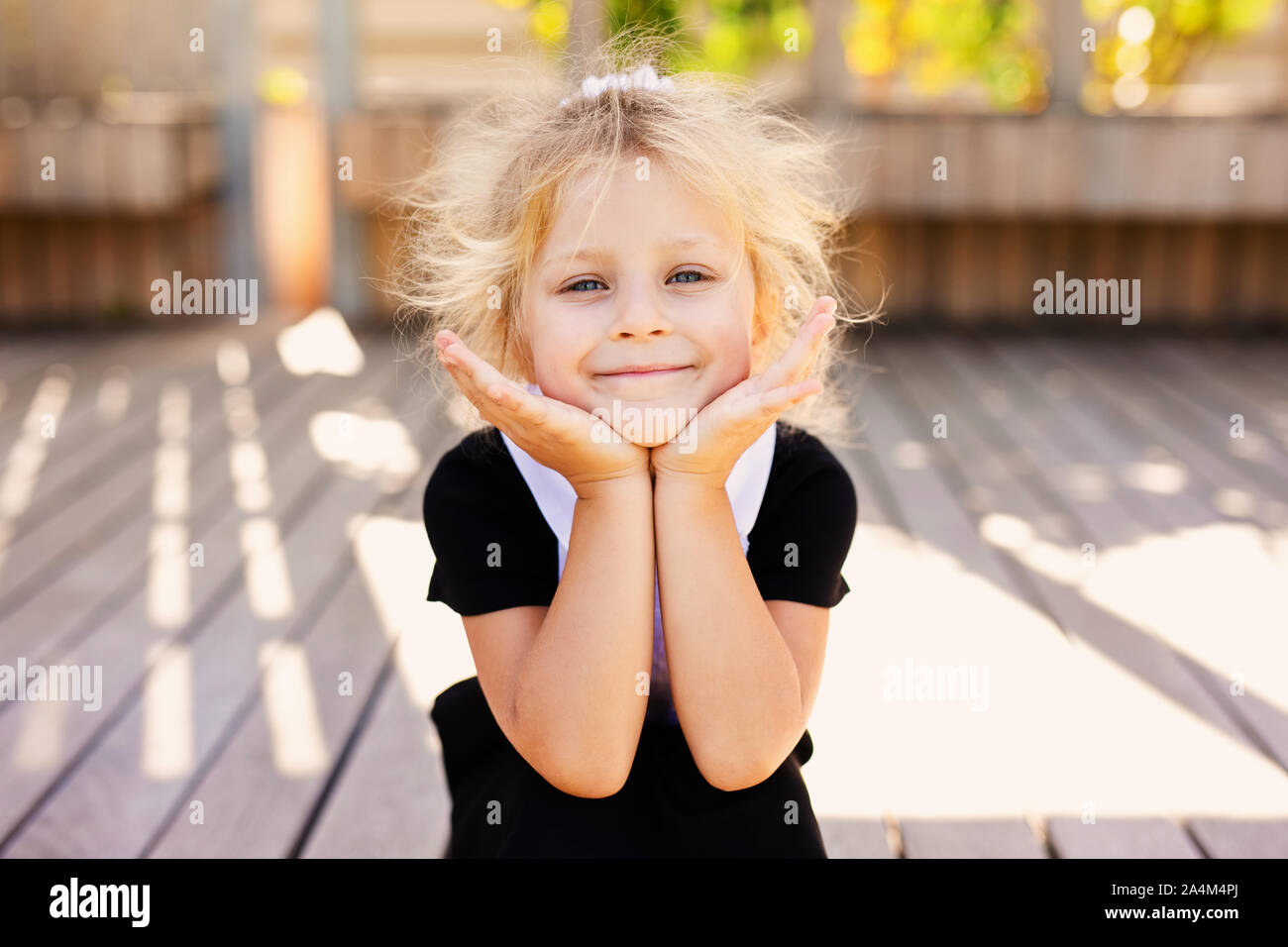 Happy little b;onde schoolgirl smiling in the park. Back to school ...