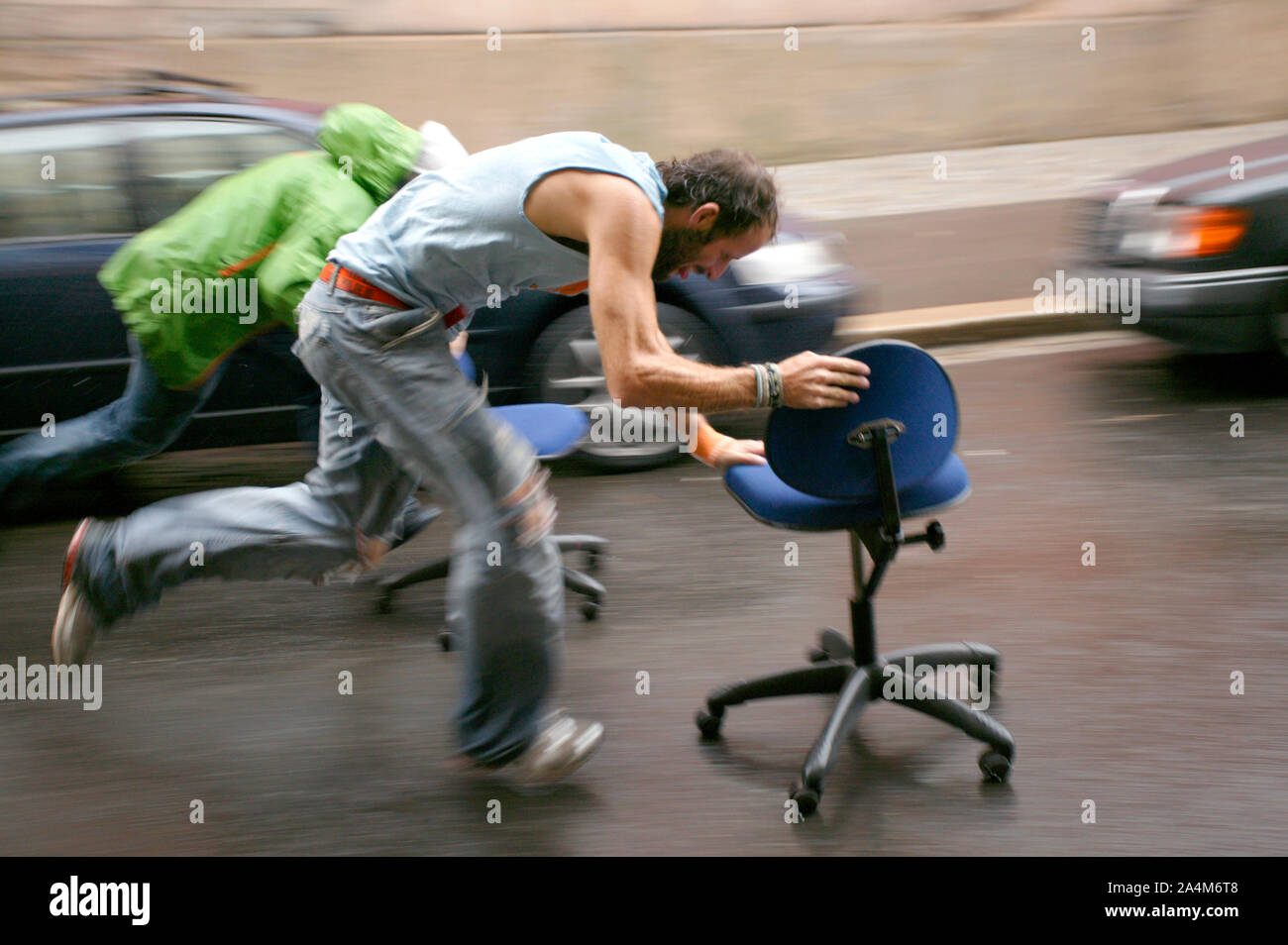 Men running with office chairs Stock Photo - Alamy