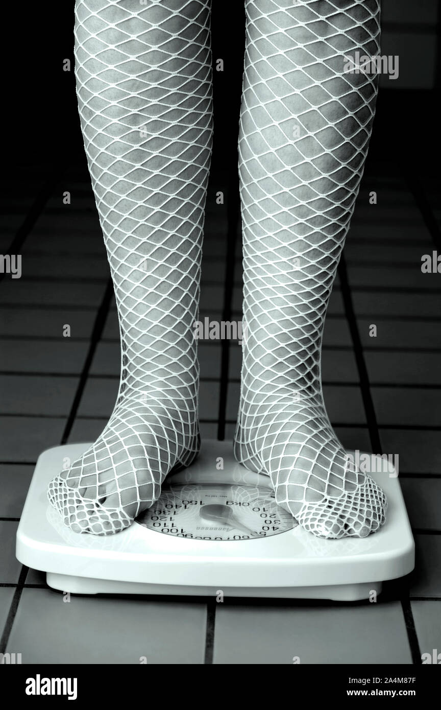 Woman standing on scales Stock Photo - Alamy