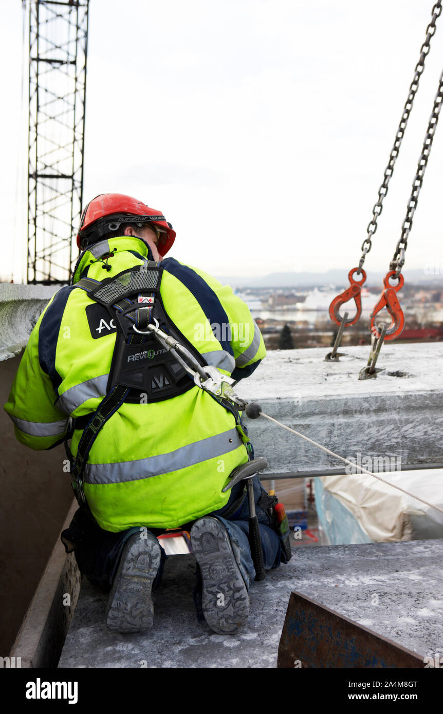 Construction worker working outside building. Safety line ...