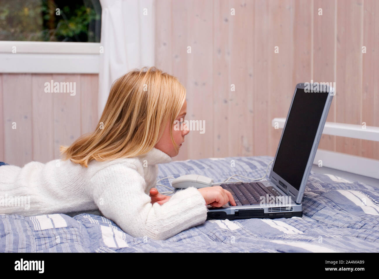 Girl with laptop in bed Stock Photo - Alamy