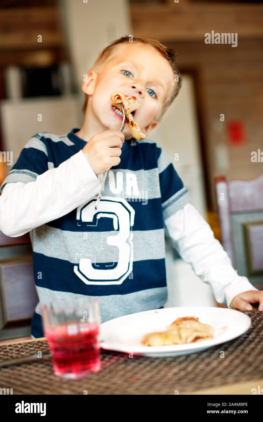 Young boy eating Stock Photo - Alamy