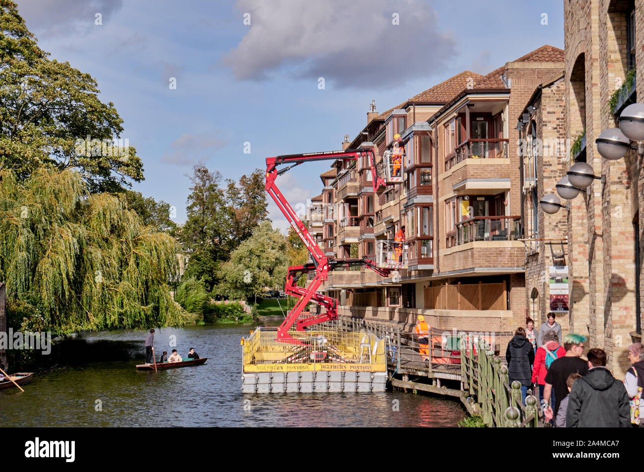 Cambridge, UK - October 9, 2019: Workers on aerial work platforms paint ...